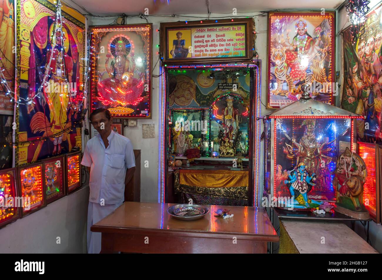Hinduism, Hindu temple, Brahmin in temple with colourful deities ...