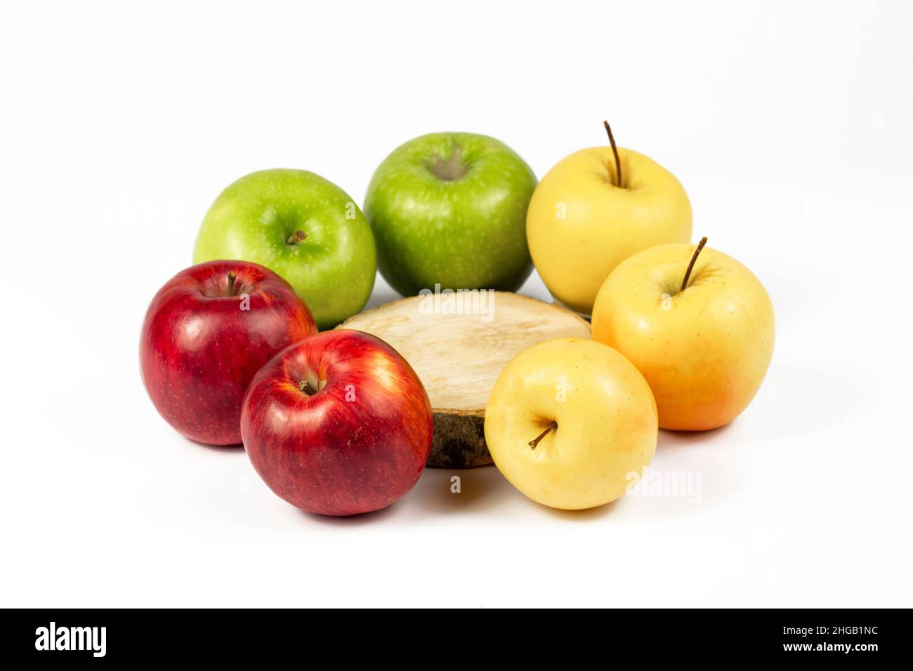 Various color apples and cross cut wooden logs isolated on white ...