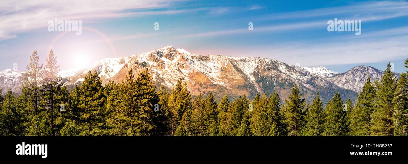 Panoramic landscape with sunlight shining above the snow capped ...