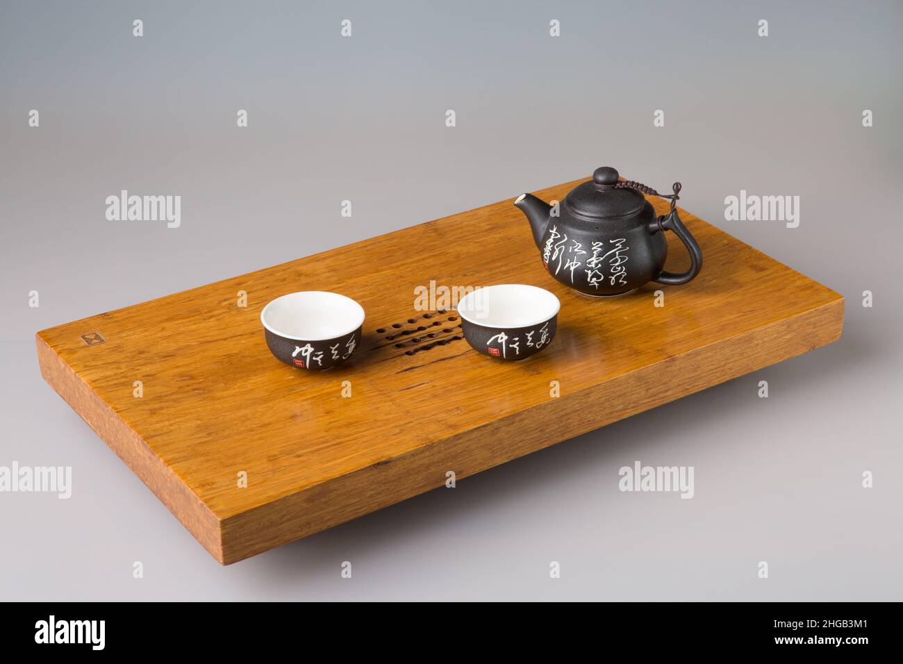 Two traditional Asian tea cups and a teapot. Service on a wooden table ...