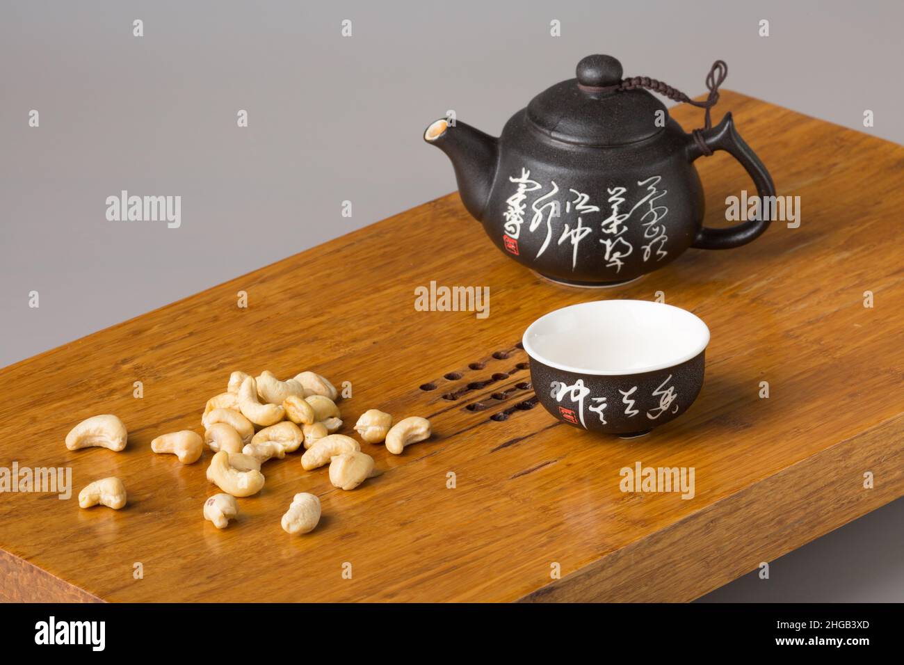 Traditional Asian tea cup and teapot. Service and cashew nuts on a ...