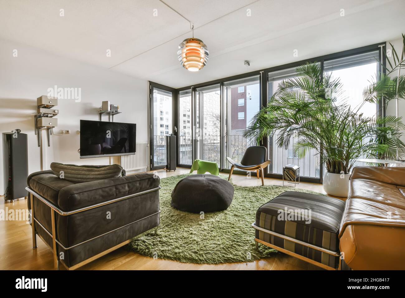 Cozy and stylish living room with green carpet near sofas and ottomans ...