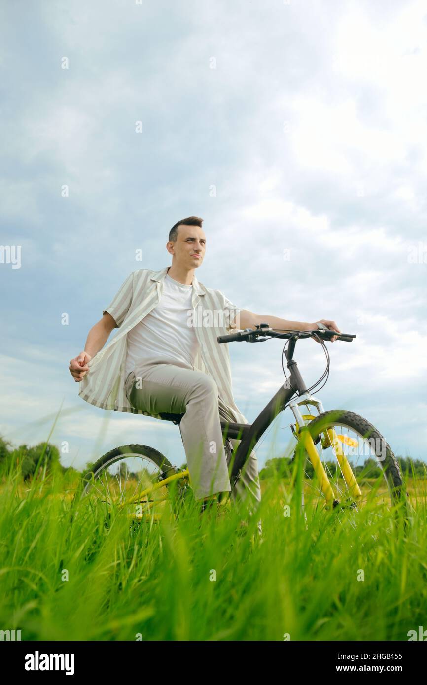 The man is riding a mountain bike. A fashionable guy came to nature in ...