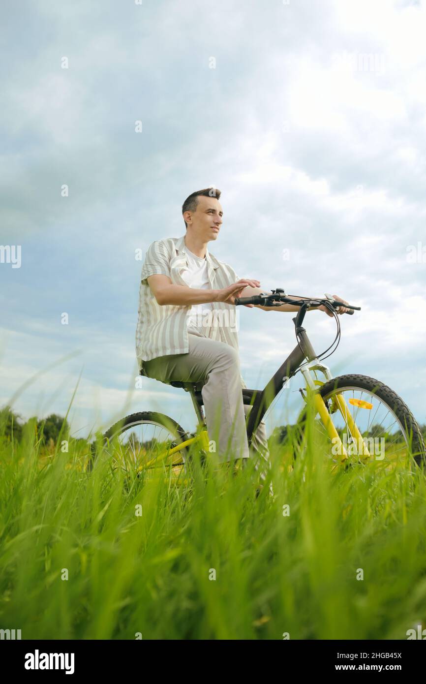 The man is riding a mountain bike. A fashionable guy came to nature in ...
