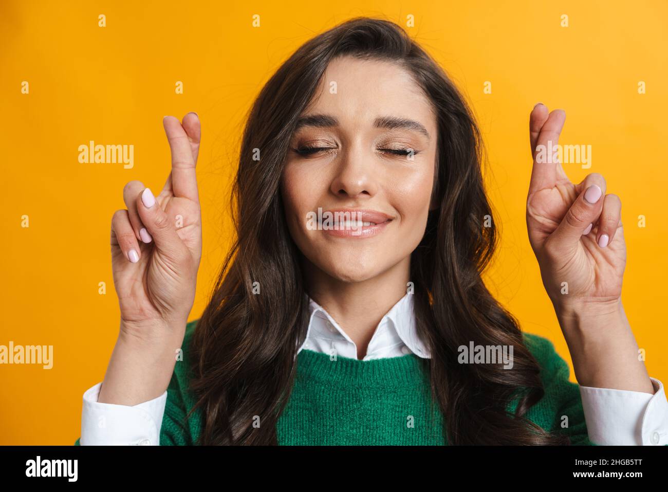 Portrait of a smiling casual woman standing over yellow background ...