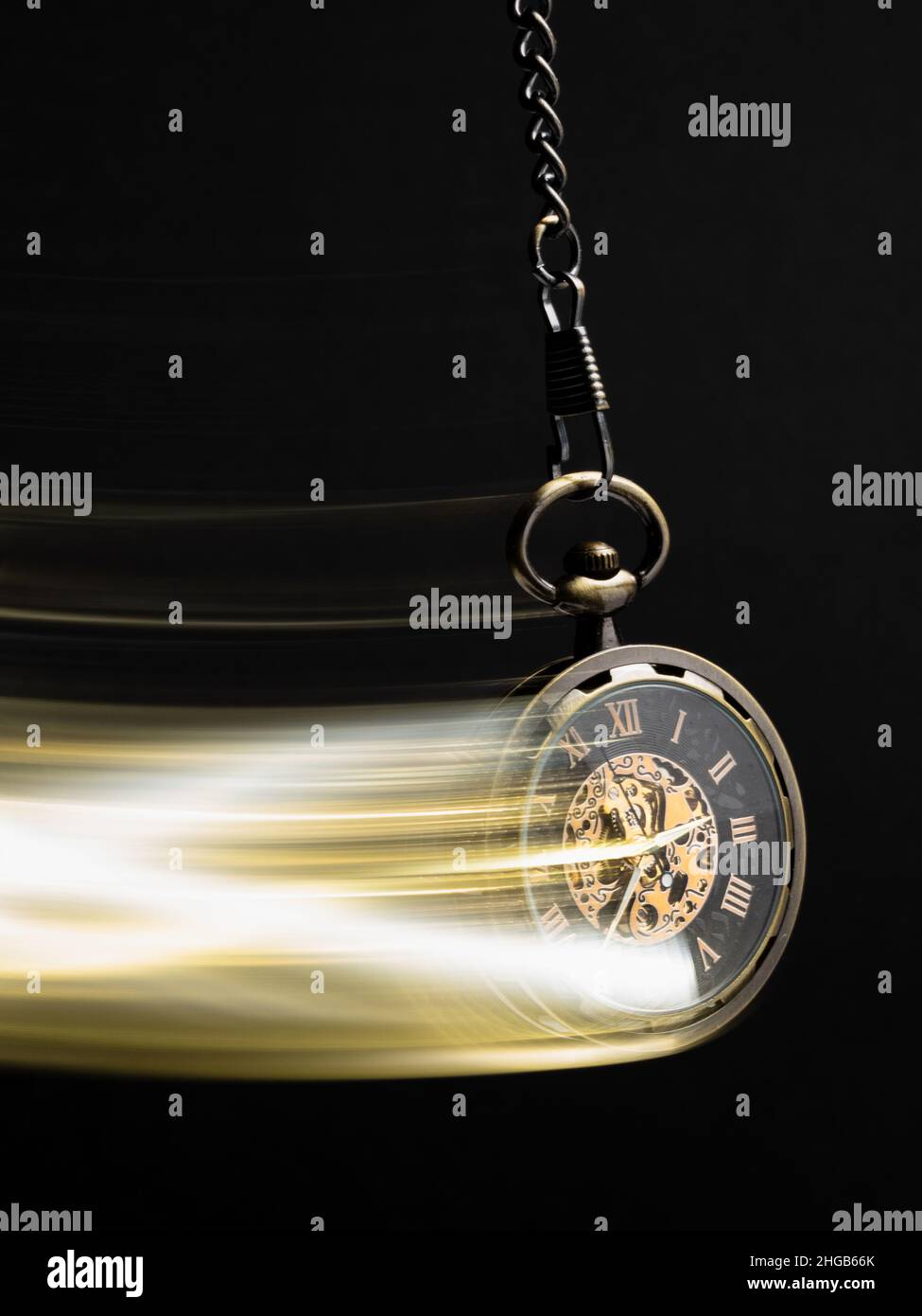 A time piece swinging with a trail of movement Stock Photo - Alamy