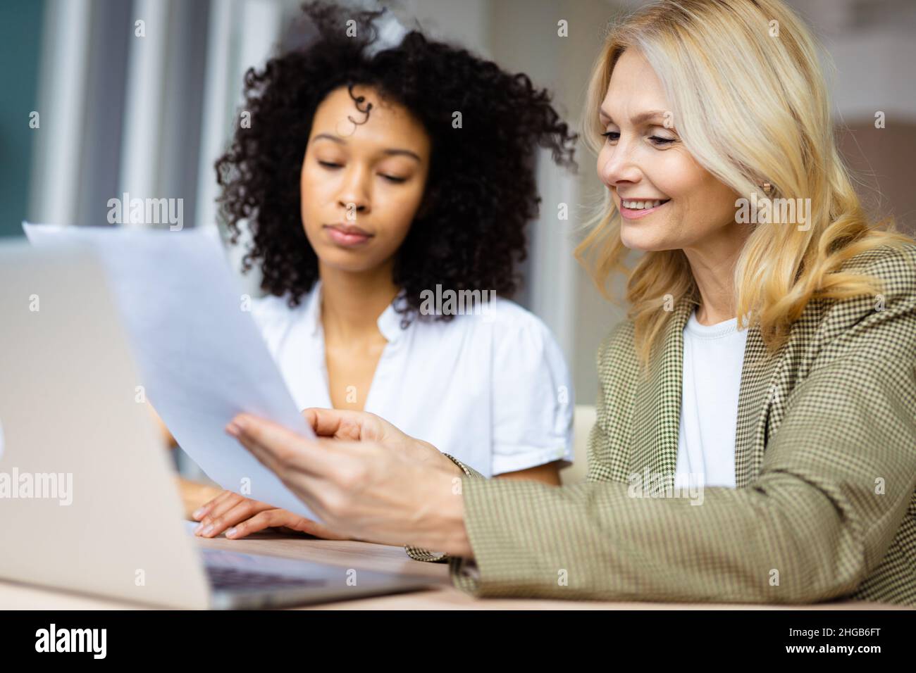 Beautiful adult businesswomen with elegant dress sitting at computer ...