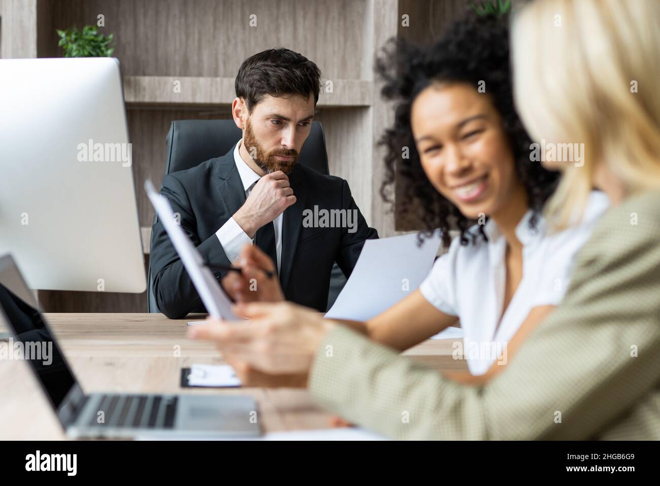 Multiracial group of businesspeople with elegant dress sitting at ...