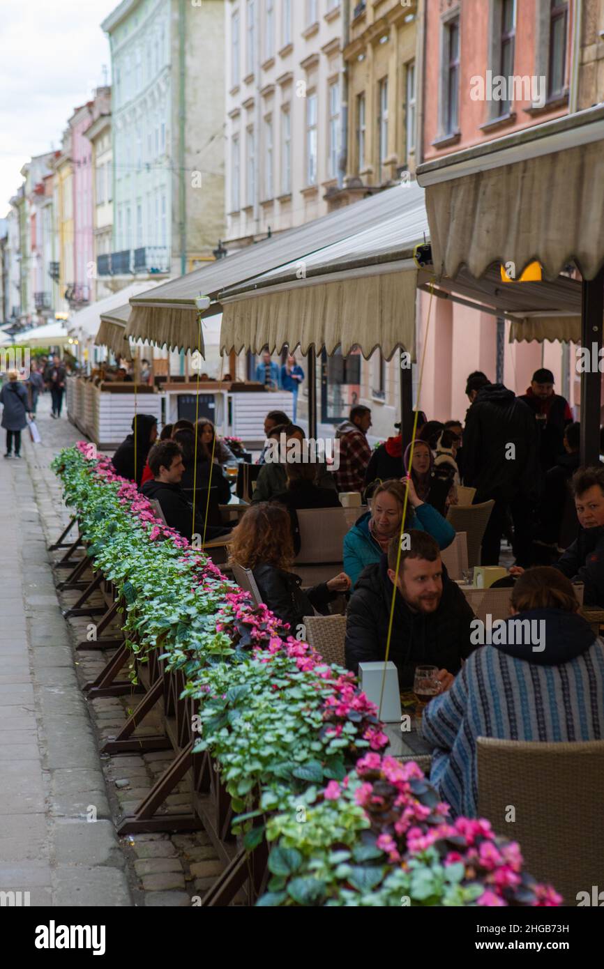 Lviv, Ukraine - May 14, 2021: people at outdoors street cafe flexing talking relaxing Stock ...