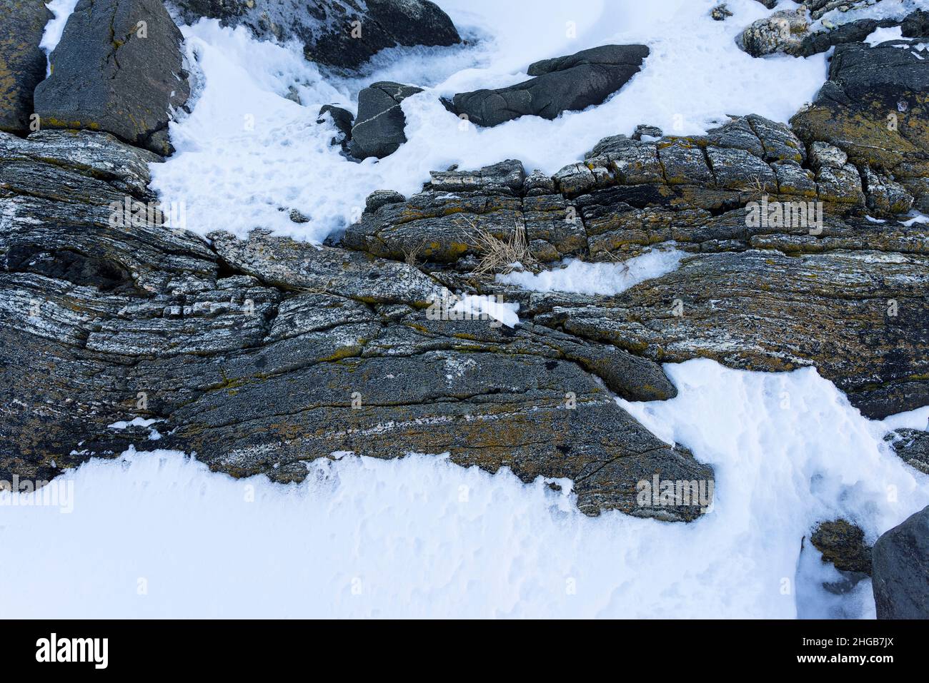 Granite layered rocks covered with snow in the arctic , Close up view ...