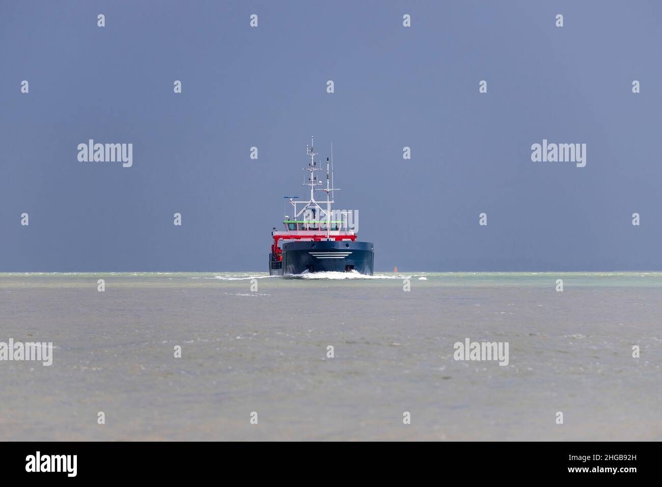 Big ship sailing by sea. The background is a blue sky without clouds ...