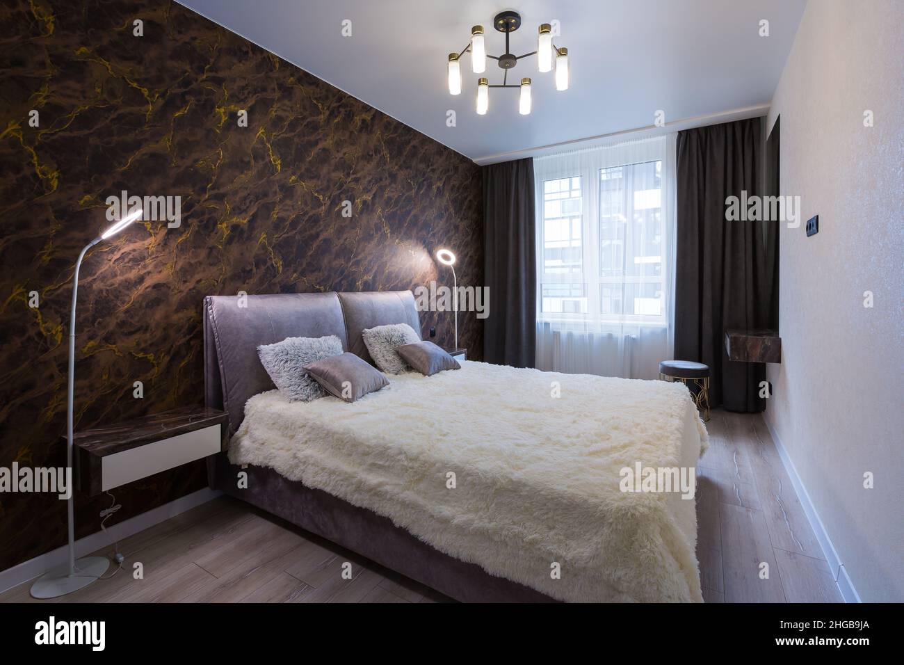 Interior of a modern bedroom with a large bed Stock Photo - Alamy