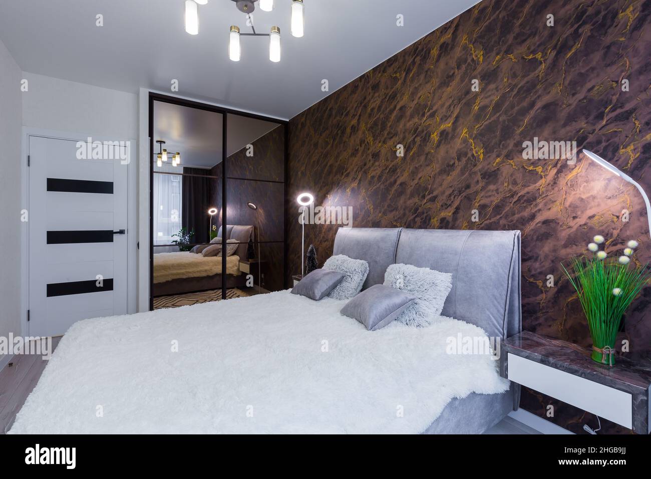 Interior of a modern bedroom with a large bed Stock Photo - Alamy