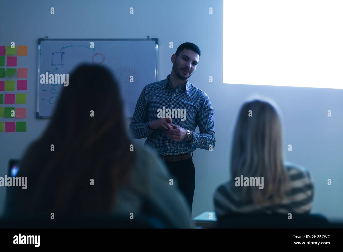 Back view of students during class during lecture. Professor next to a ...