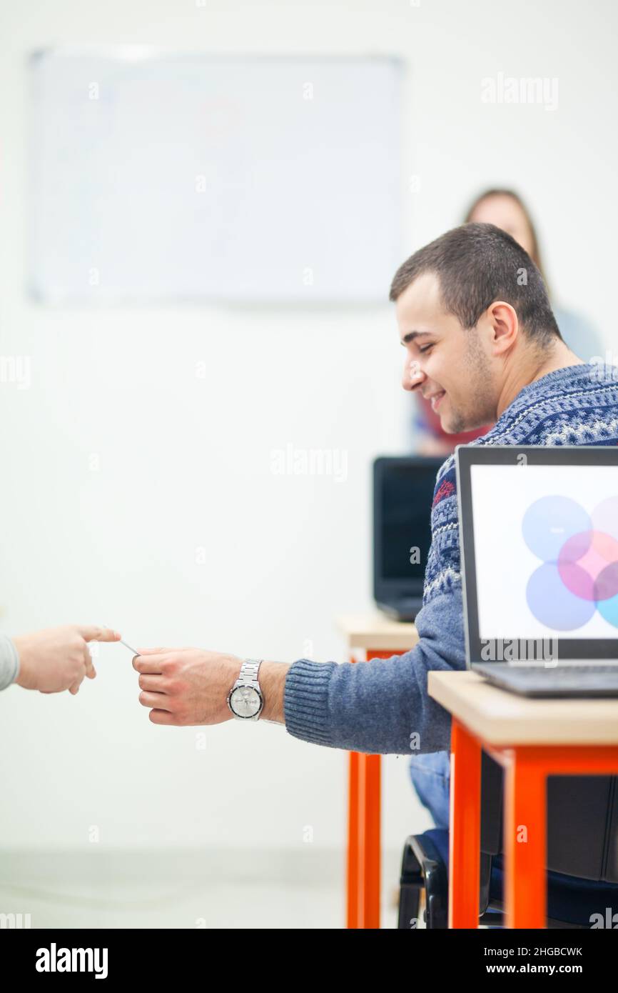 Students secretly passing sheets of paper during exam in a modern ...