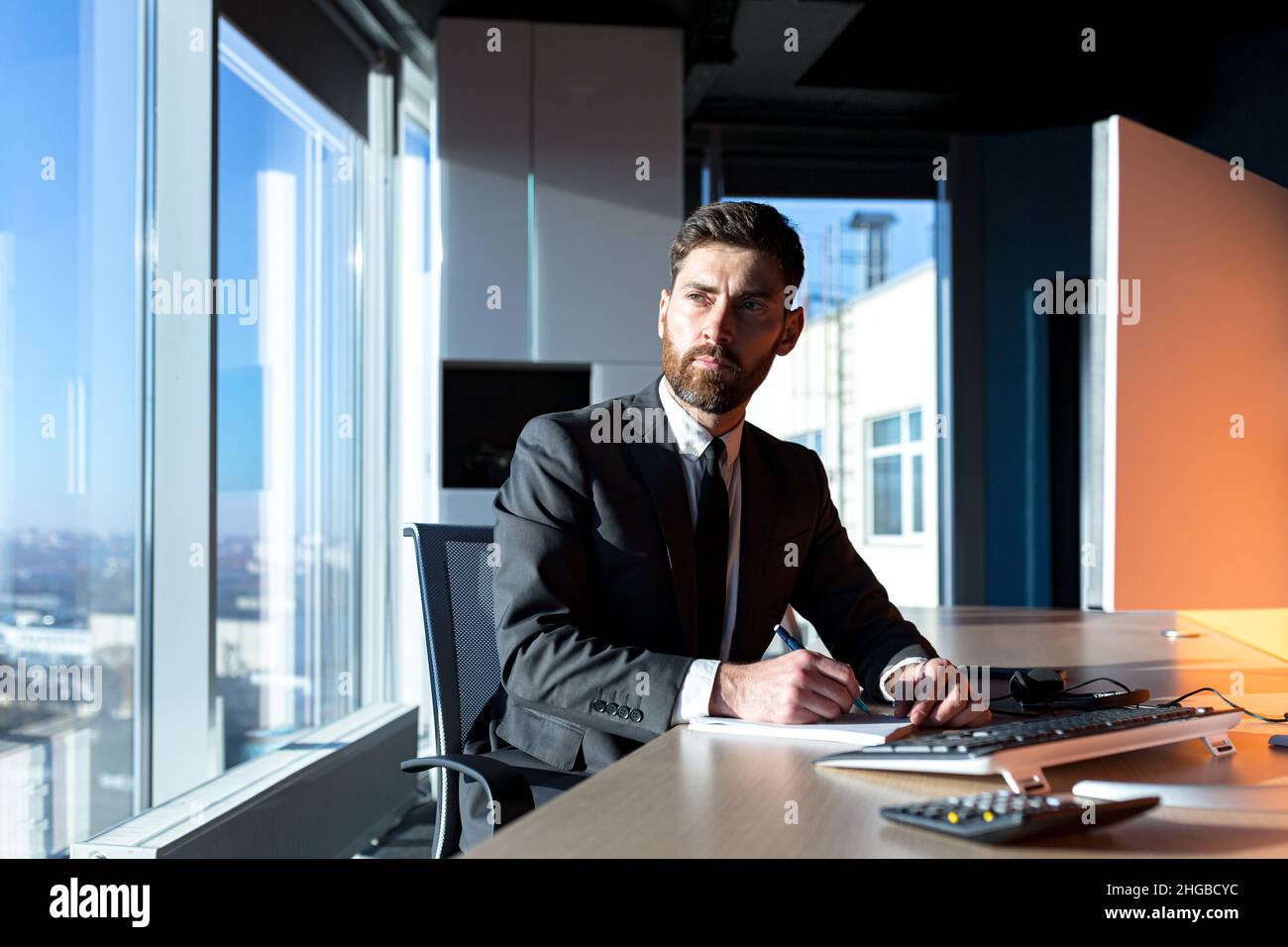 Serious bearded businessman boss working at computer in modern office ...