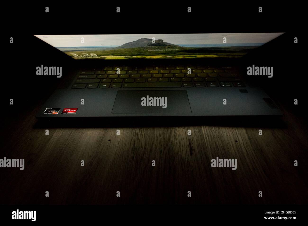 Laptop computer screen lighting up a dark desk Stock Photo - Alamy