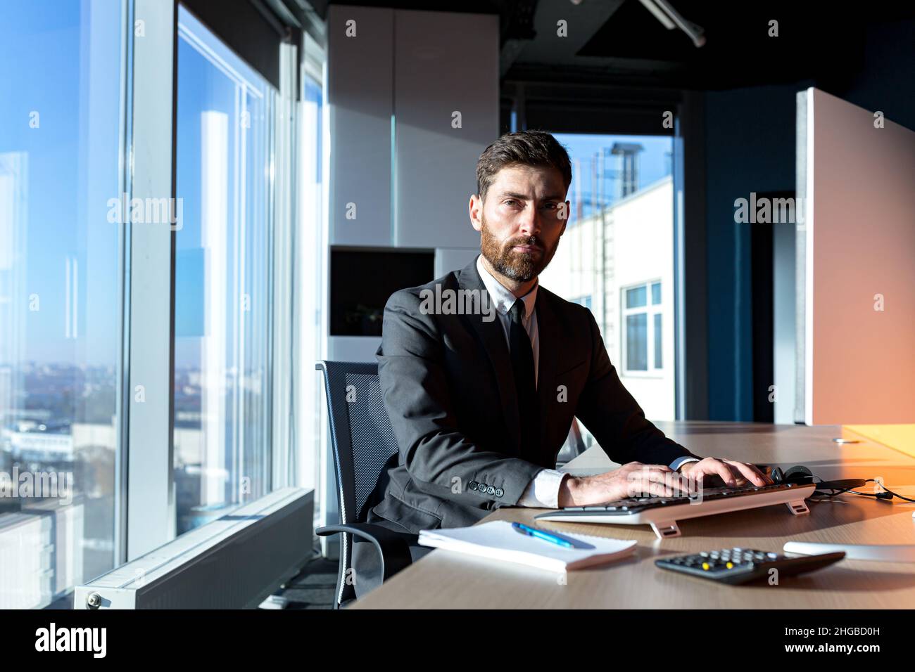Serious bearded businessman boss working at computer in modern office ...