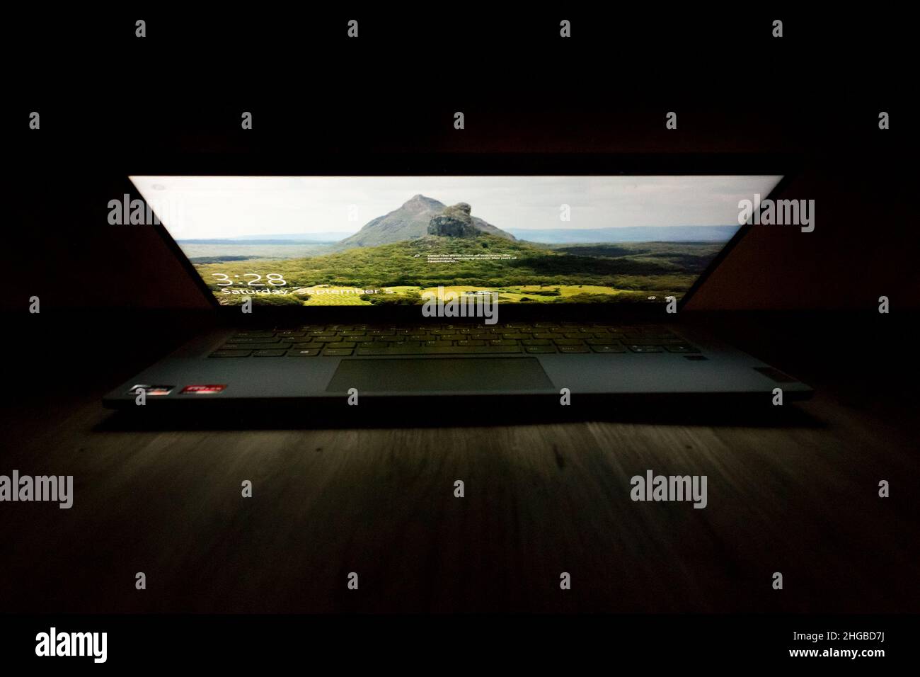 Screen from a laptop computer lighting up a dark room Stock Photo - Alamy