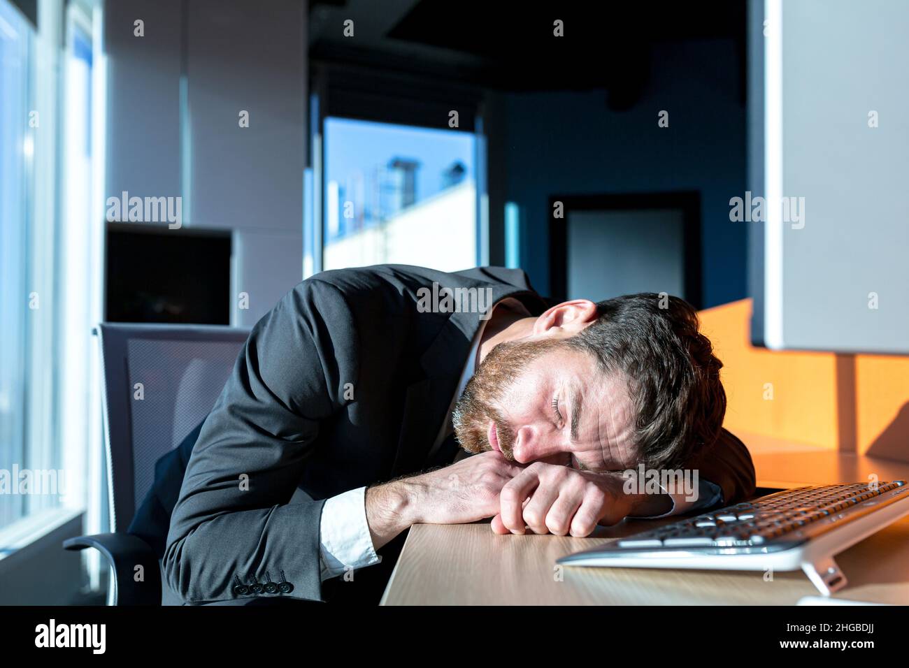 Close-up photo of a businessman, man sleeping at his desk, during the ...