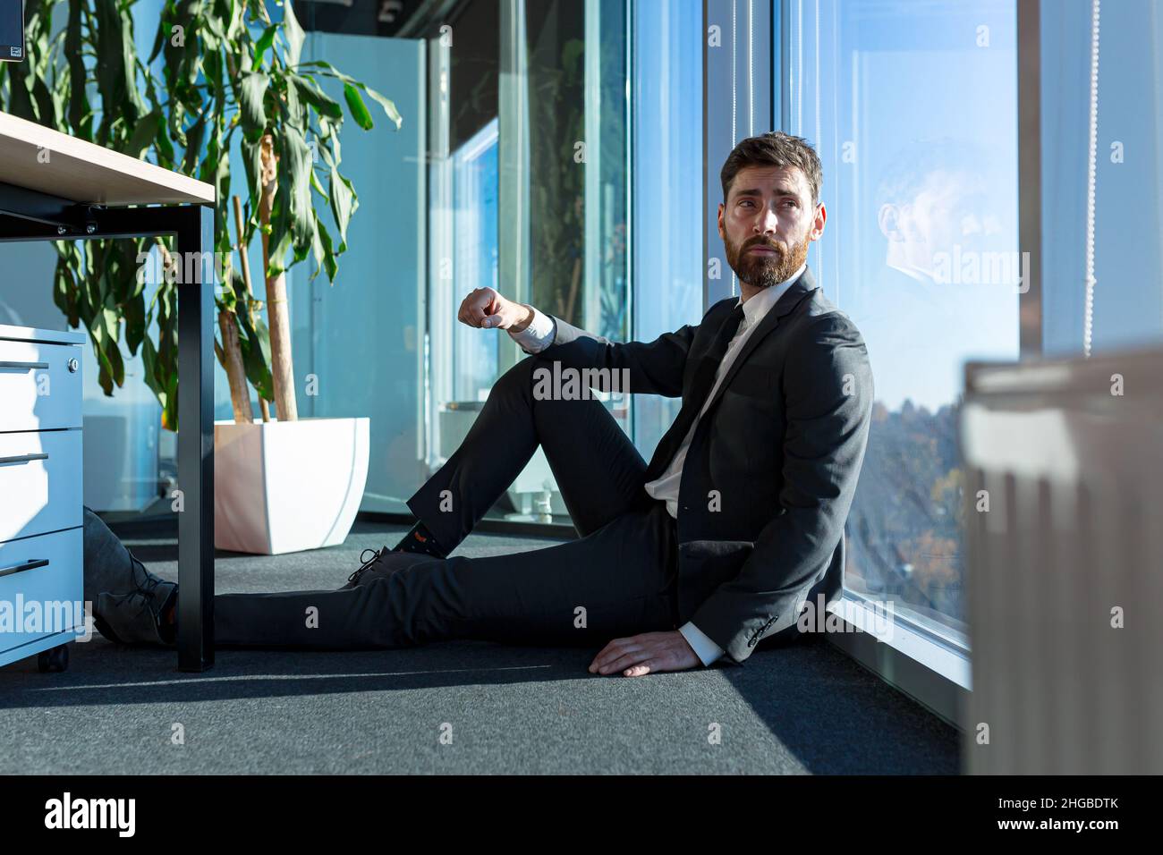 Depressed man sitting on office floor, employee disappointed and fired ...