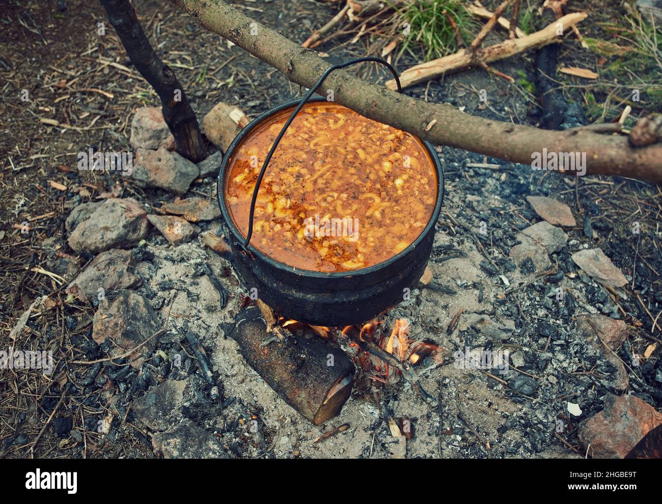 Cooking in field conditions, boiling pot at the campfire on picnic ...