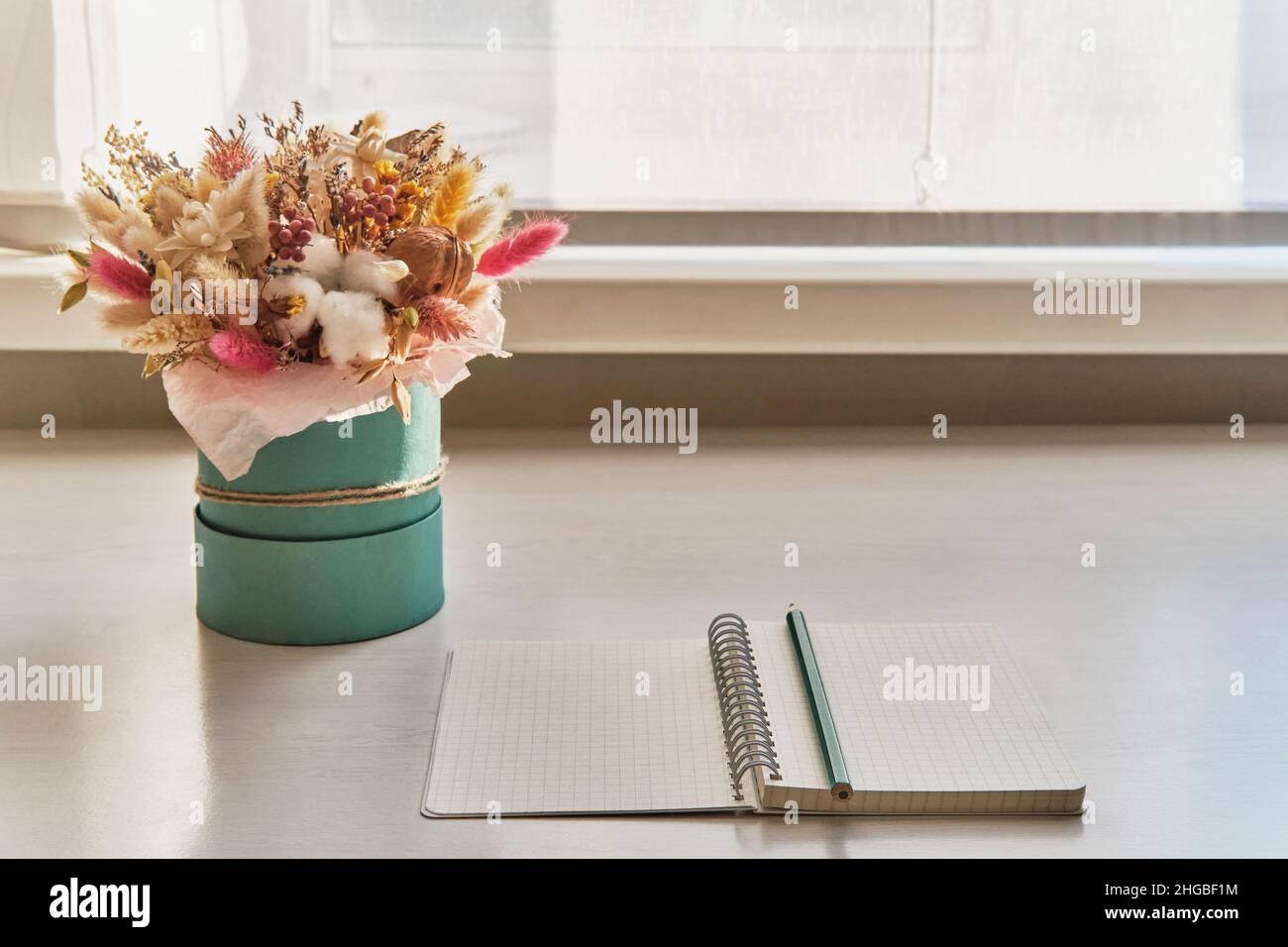 Open blank notebook with turquoise pencil, beautiful fluffy bouquet of ...