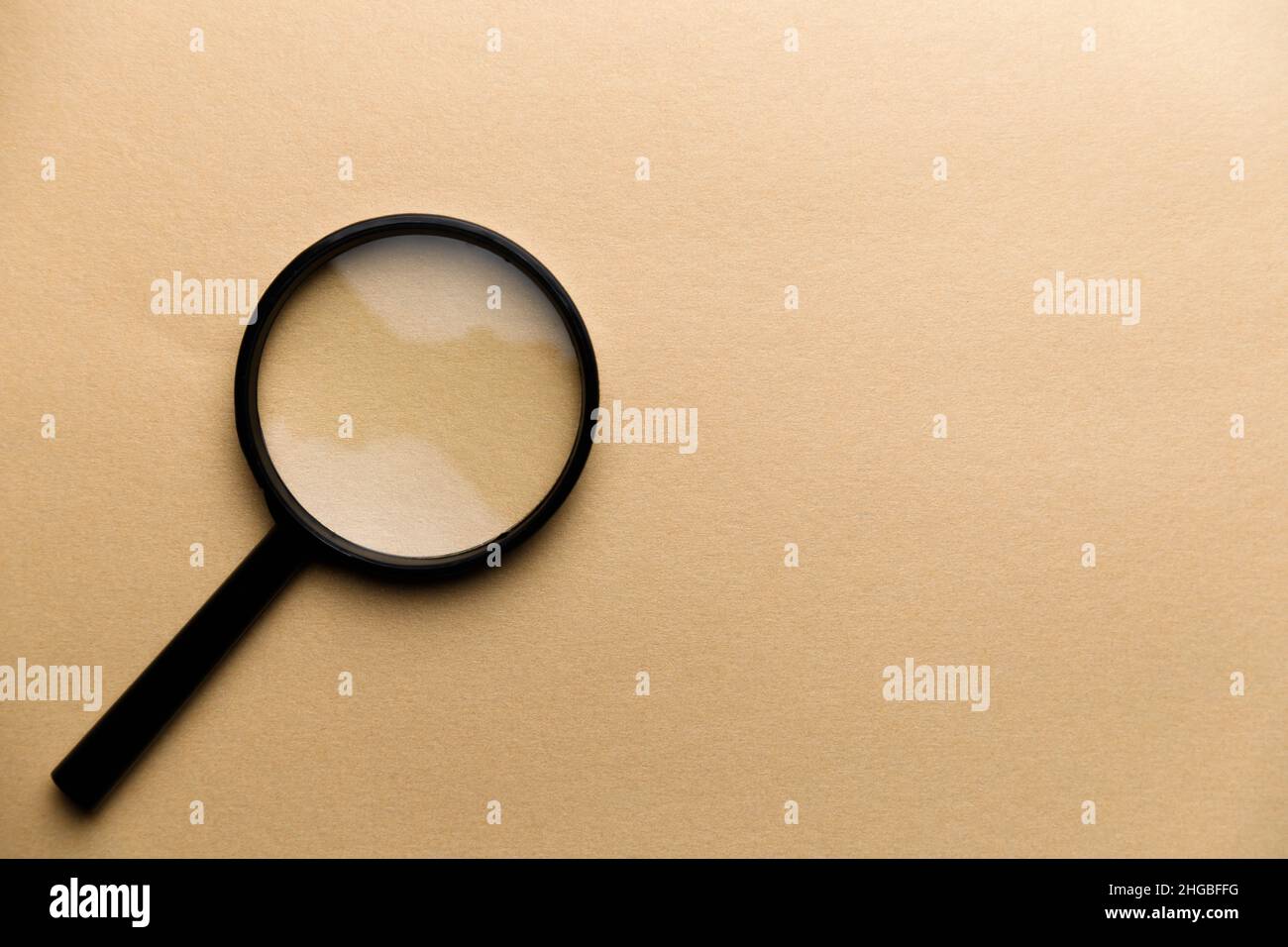 a golden magnifier on yellow paper background Stock Photo - Alamy