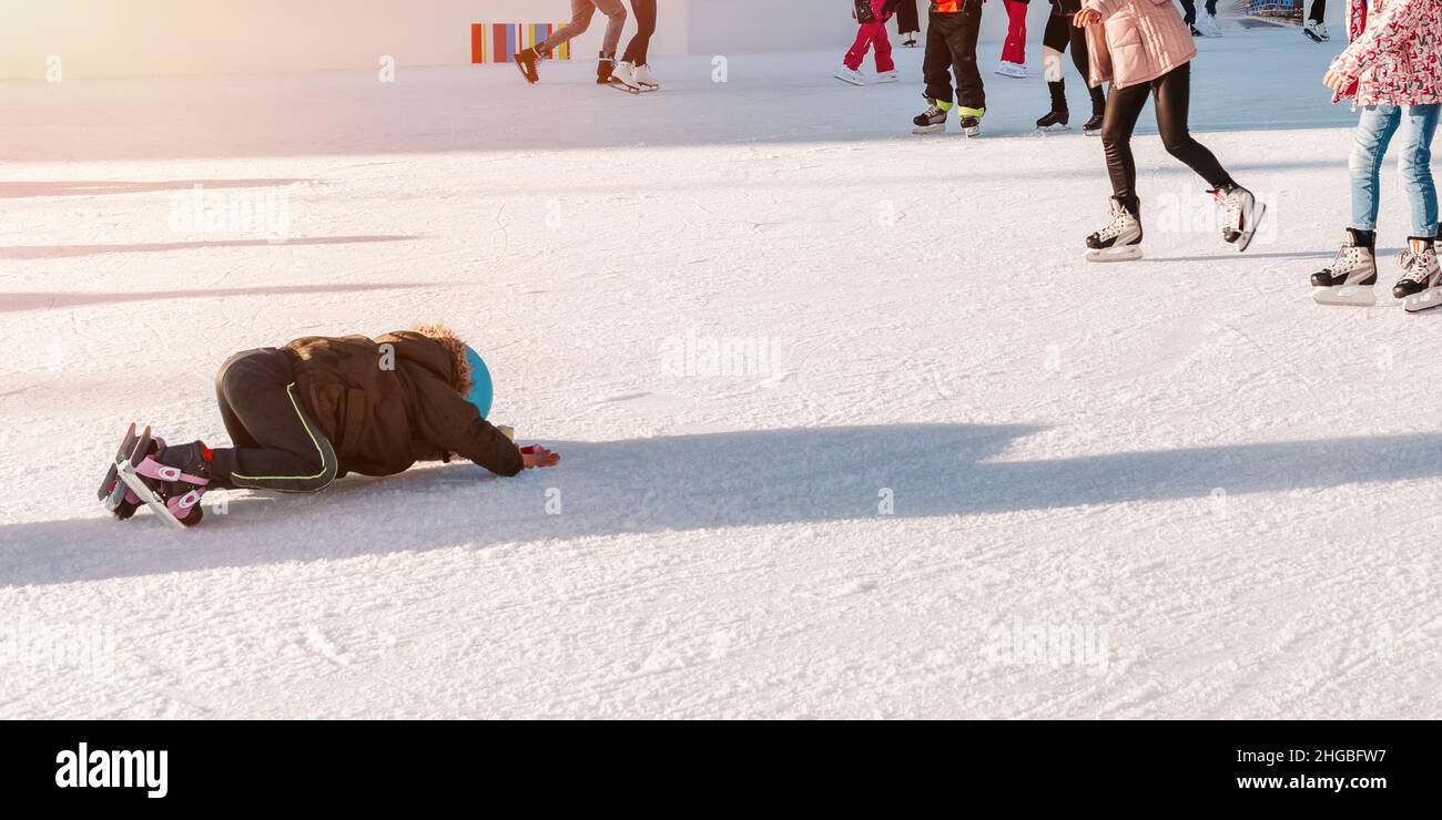 Soft,Selective focus.The child fell on the rink while skating.Adorable ...