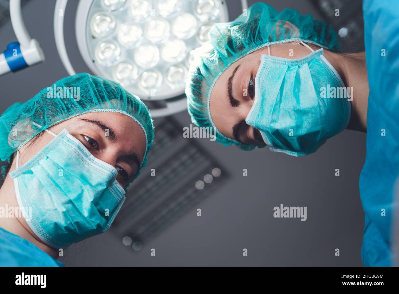 From below female surgeons in medical uniform using professional tools ...