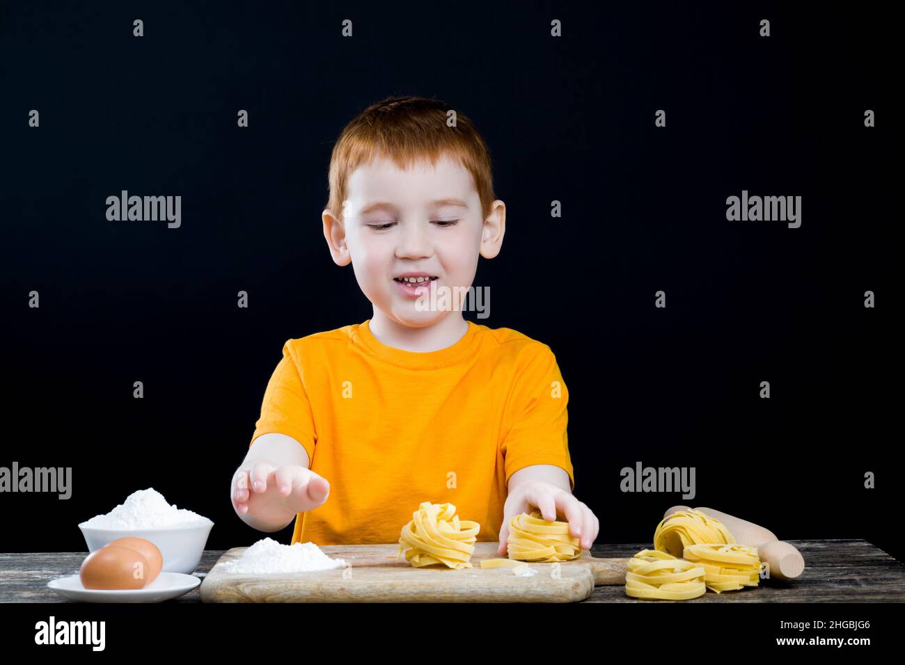portrait of a baby boy in the kitchen while helping to prepare food, a ...
