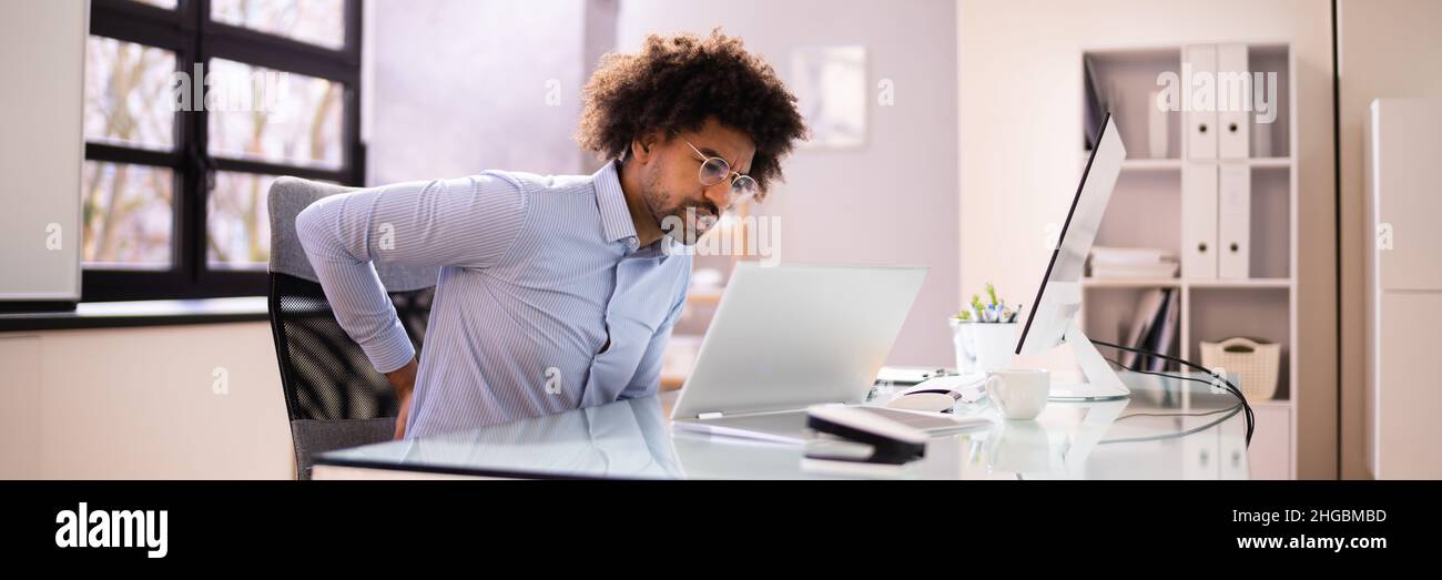 Back Pain Bad Posture Man Sitting In Office Stock Photo - Alamy