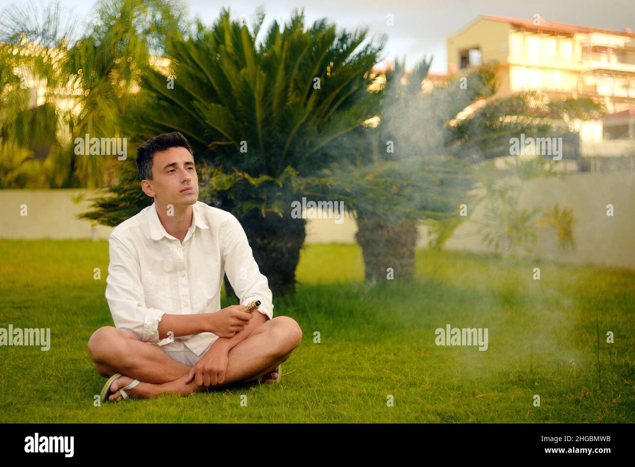 A vape man on vacation, under a palm tree. Rest, smoking, nicotine ...