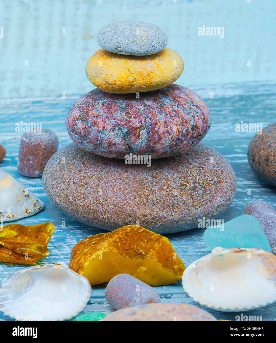 Sea pebbles and seashells on the table. A pyramid of sea stones on a ...