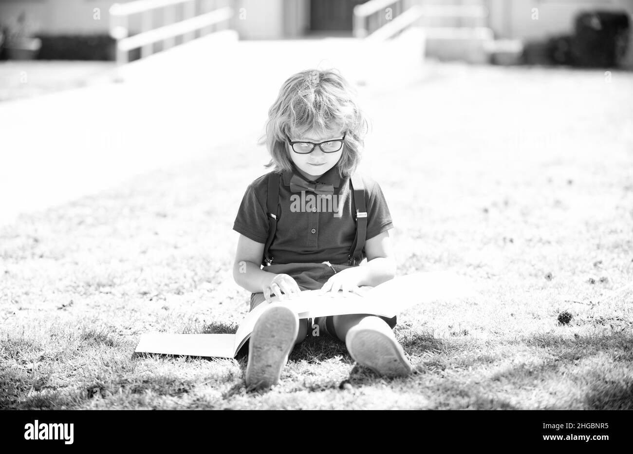 smart curious nerd in glasses reading book study with copybook outdoor ...