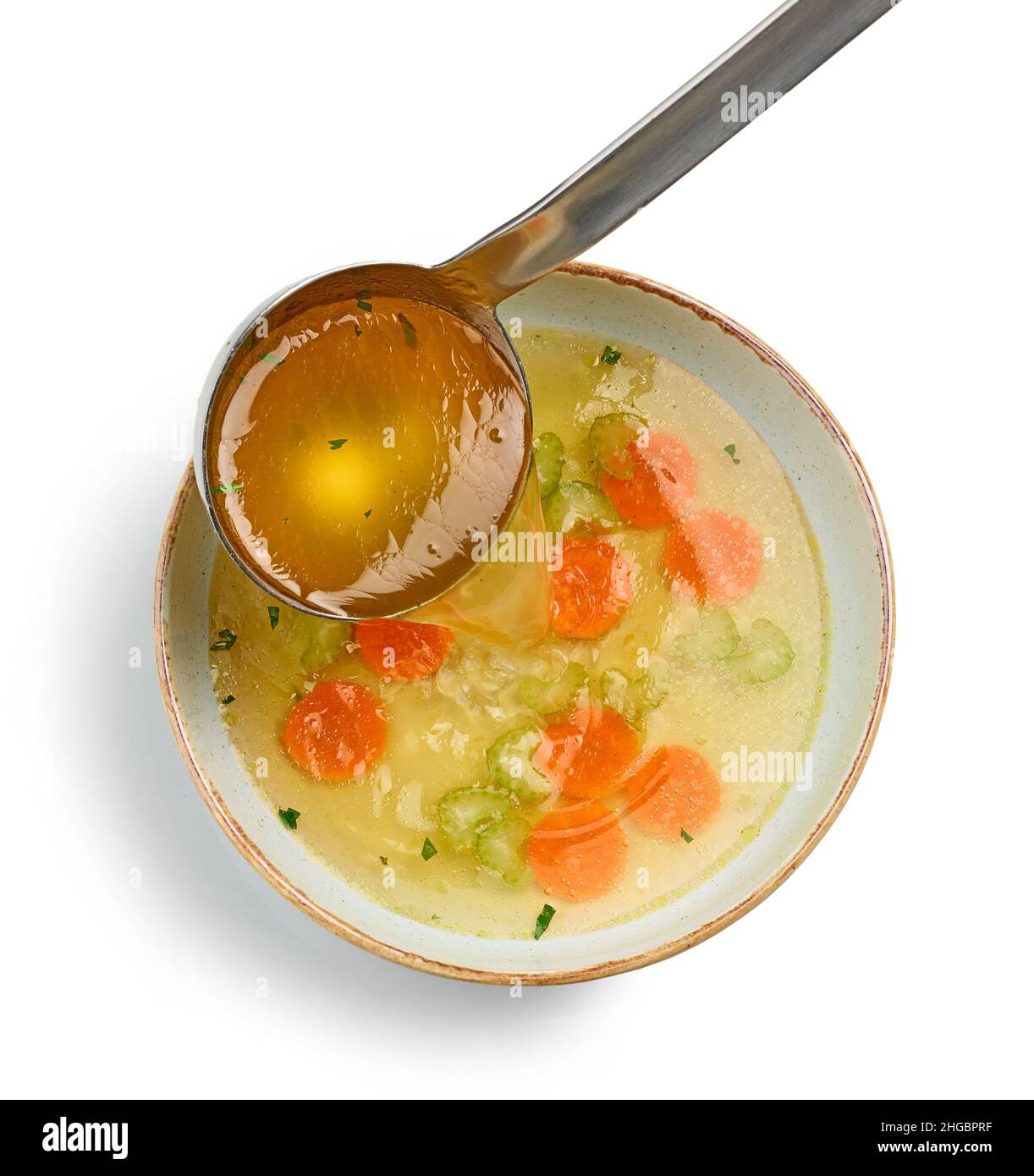 broth soup pouring into bowl isolated on white background, top view ...