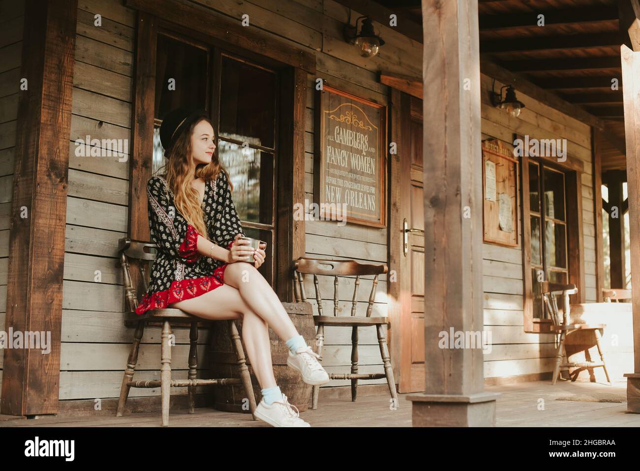 A woman is resting on a terrace near a western house, a weekend in an ...