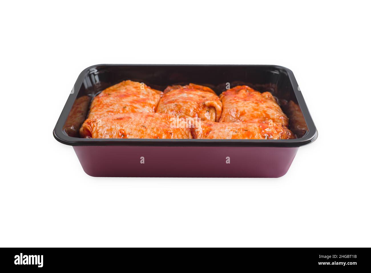Raw marinated chicken thighs in red sauce in a tray for a supermarket ...