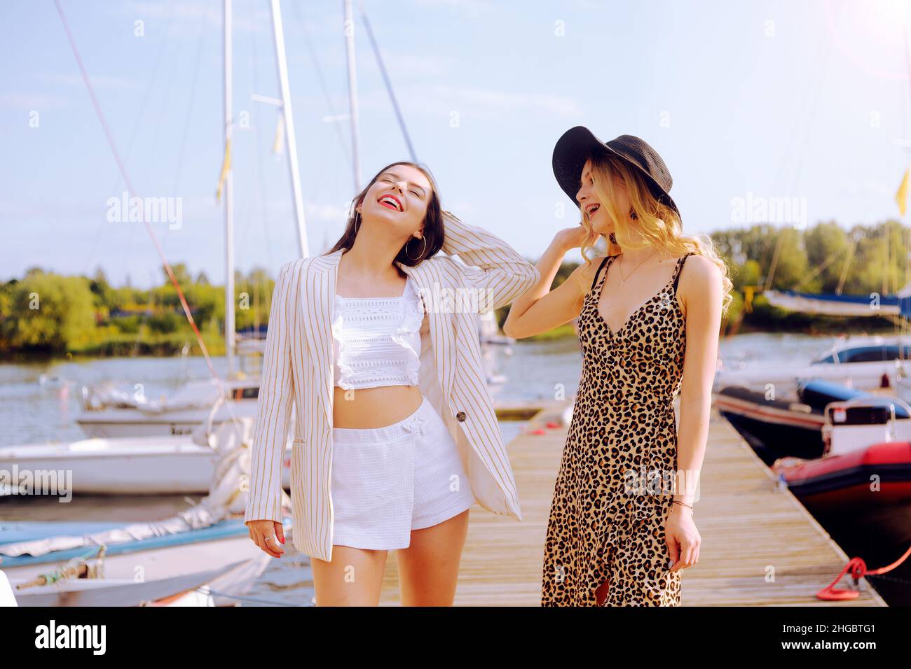 Two girls on the background yachts, sailing boats are smiling, looking ...