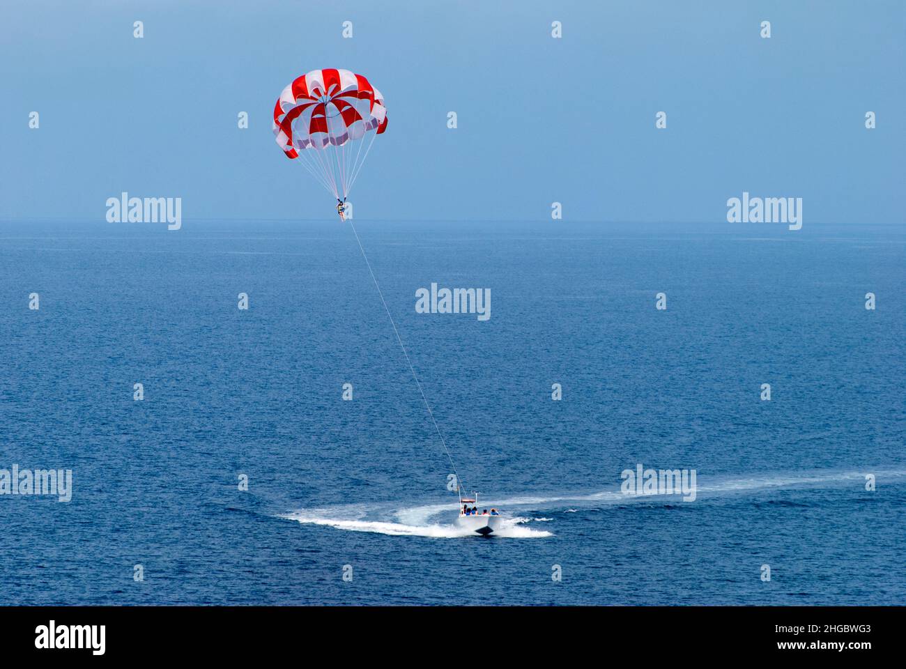 The motorboat pulling the red color parachute - the parasailing ...
