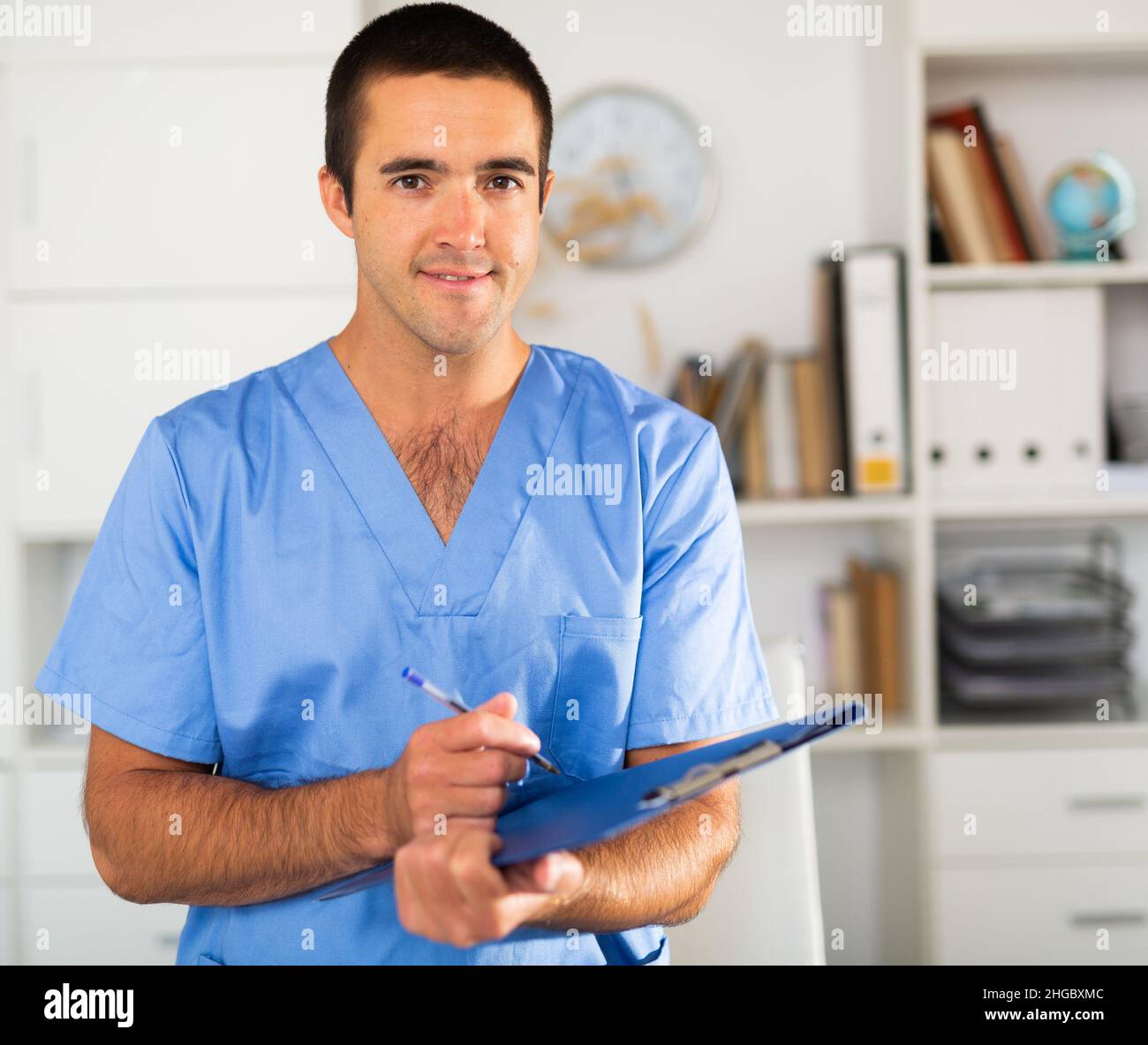 Male nurse filling out medical form on clipboard Stock Photo - Alamy