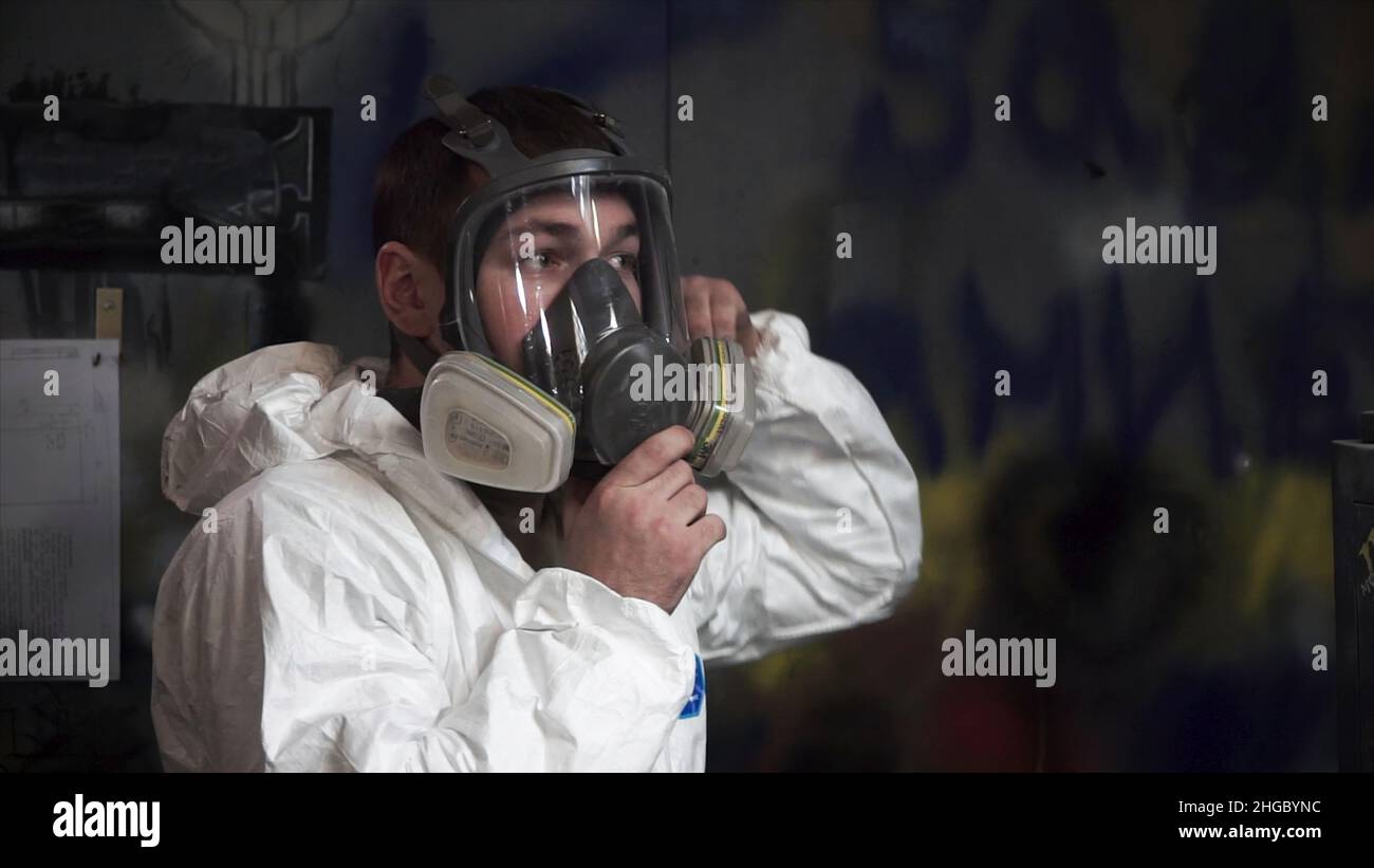 Man painting with spray paint gun in workshop. Clip. Industrial metal ...