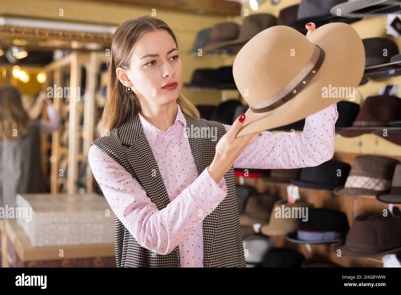 Woman choosing hat hi-res stock photography and images - Alamy
