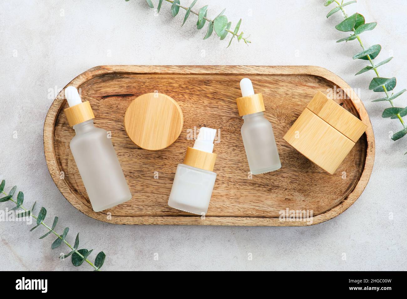 Natural cosmetics set on wooden plate with eucalyptus leaves on stone ...