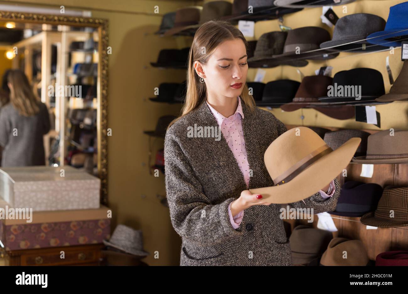 Woman choosing hat in store Stock Photo - Alamy