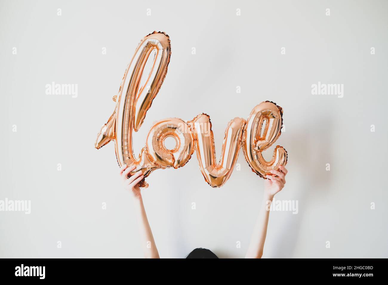 Love foil balloon in female hands. Greetings for Valentine's Day ...