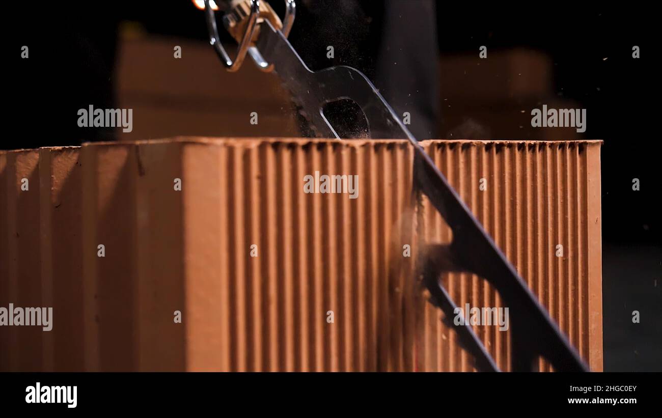 Close up of a worker using a block cutting automatic saw to prepare ...