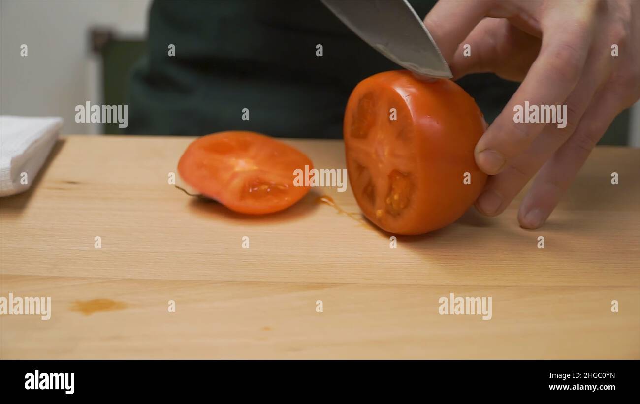Slice Tomatoes in Half. Clip. cooking, food and home concept - close up ...