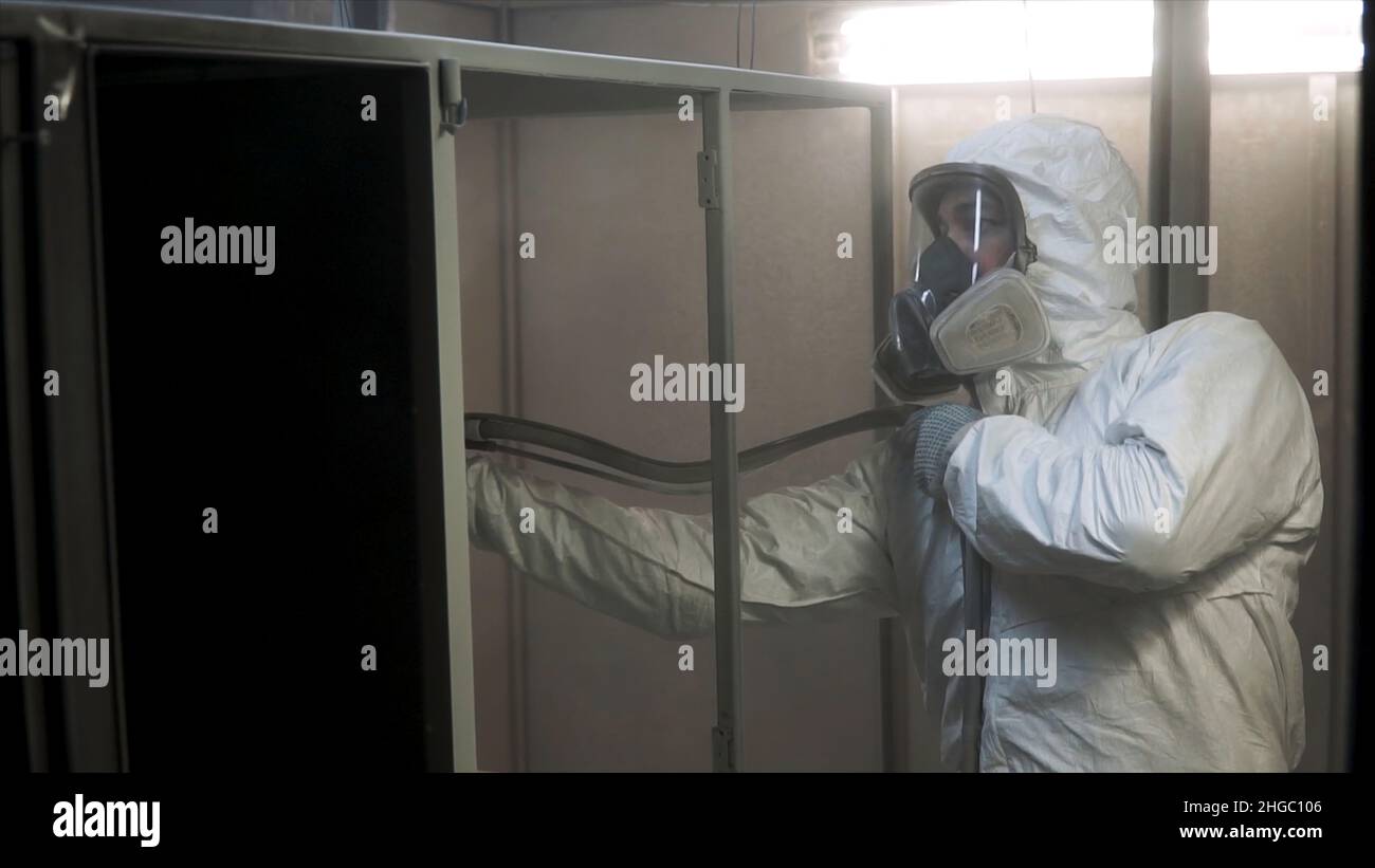 Man painting with spray paint gun in workshop. Clip. Industrial metal ...