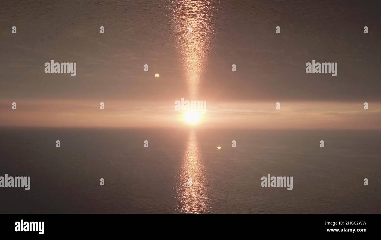 Beautiful sunset in the sea with a mirror horizon effect. Evening sun ...